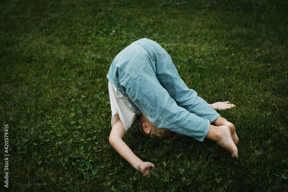 little boy rolling over in the garden Stock Photo | Adobe Stock