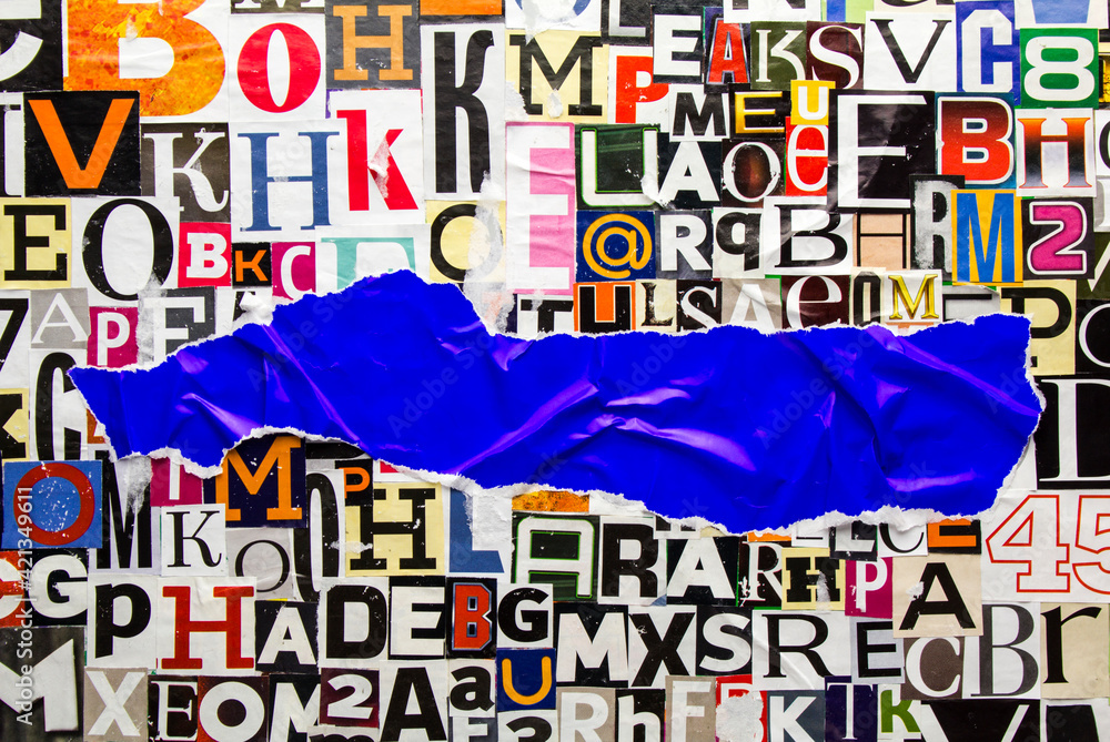 Torn and crumpled piece of blue paper on colorful abstract collage from ...