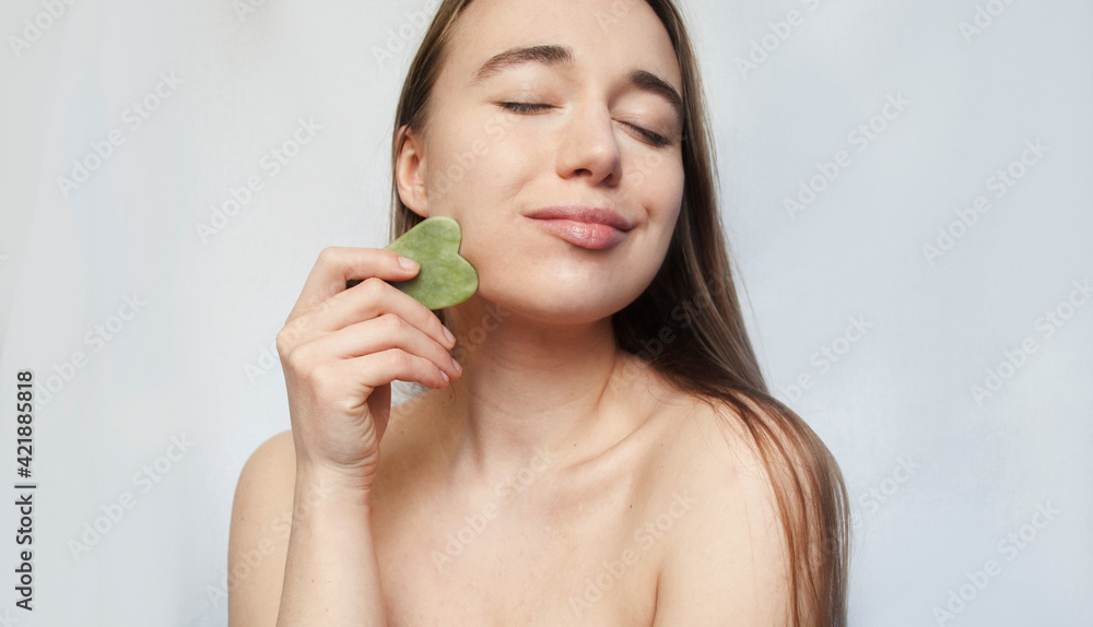 Smiling Beautiful Naked Girl Using Gua Sha Jade Face Board Against 1025