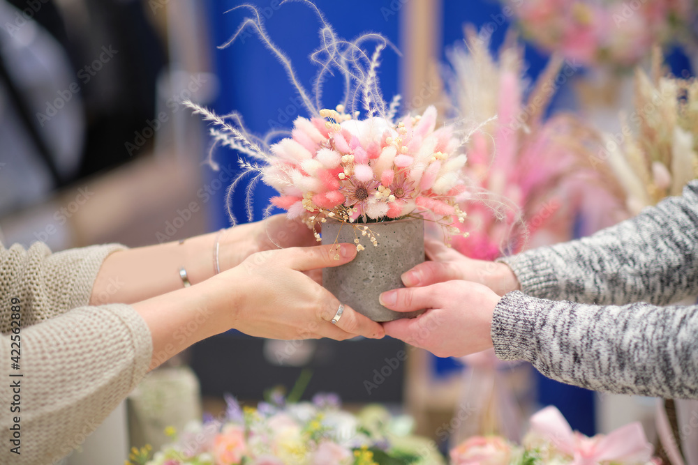 business owner selling behind counter with her bouquet of dried flowers ...
