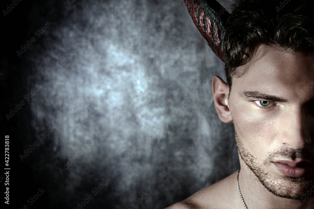 Half profile of sexy shirtless male devil with horns and room for copy ...