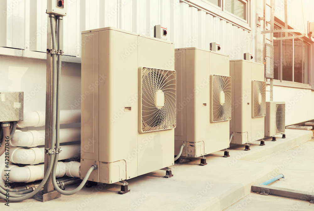 Condenser unit or compressor outside industrial plant building. Unit of ...