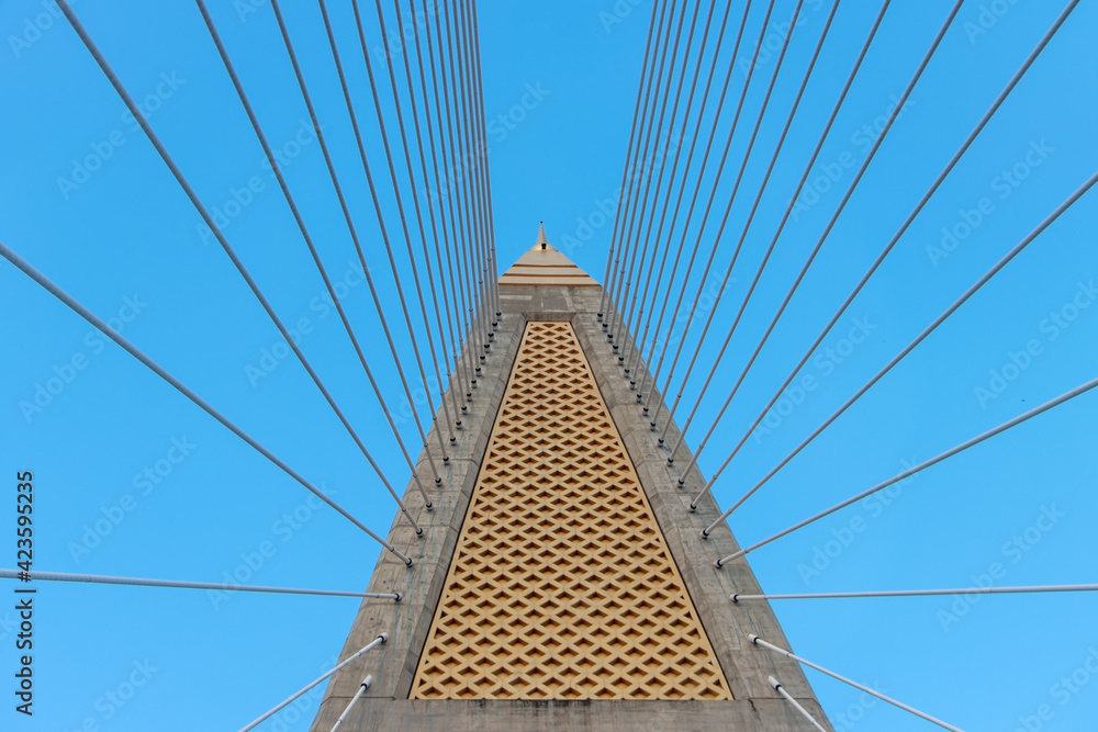 Concrete bridge pylon with parallel lines of steel cable. Passage under ...