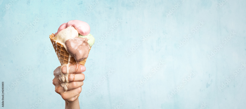 Melting ice cream cone held by a hand Stock Photo | Adobe Stock