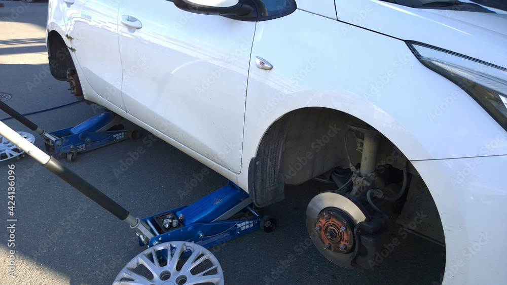 Car raised on jack. Changing flat tire on your own. Wheel replacement ...