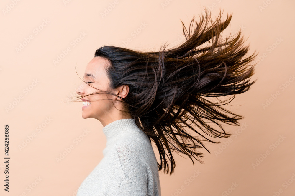 Young indian woman moving her hair isolated on beige background Stock ...