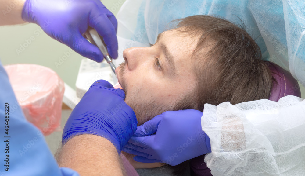 Foto Team of dental surgeons performs surgery on teeth. in a modern ...