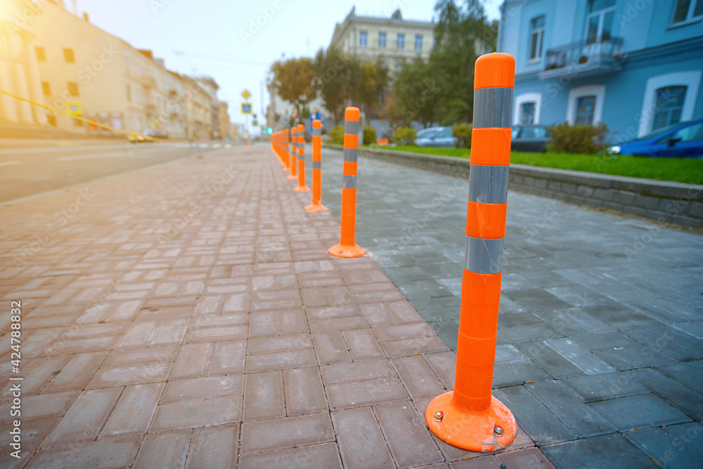 Оrange reflictive traffic bollards placed in row for safety between ...