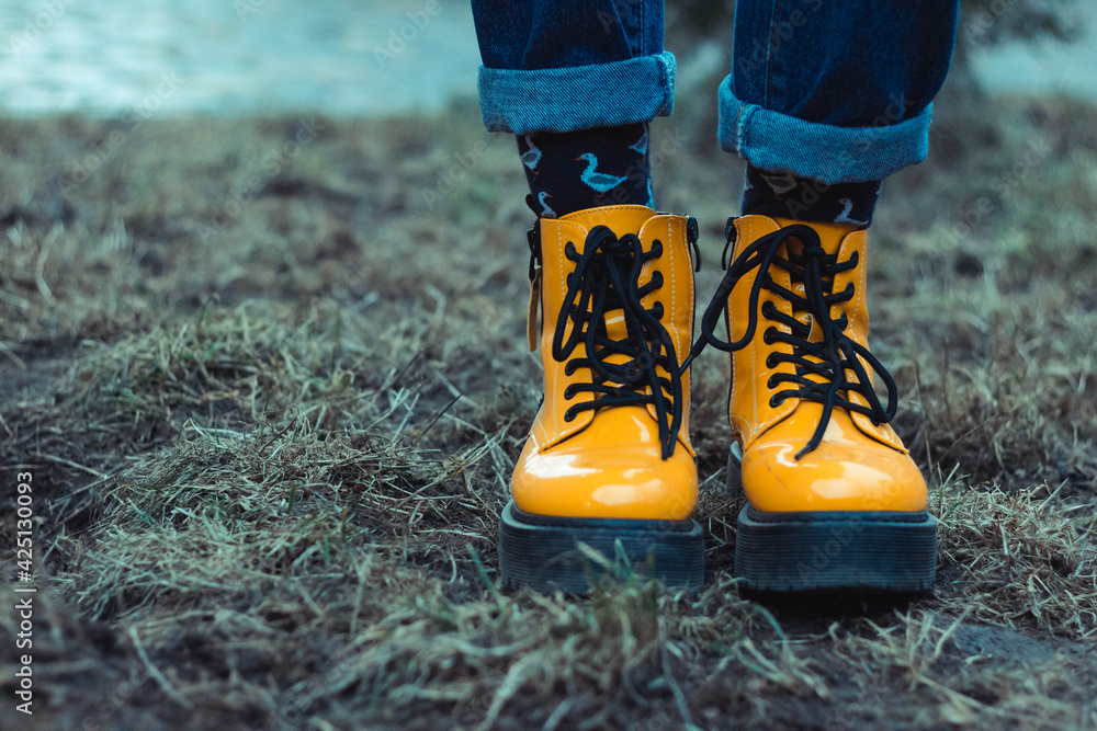 Yellow rough shoes against the background of grass. Women's feet. It's ...