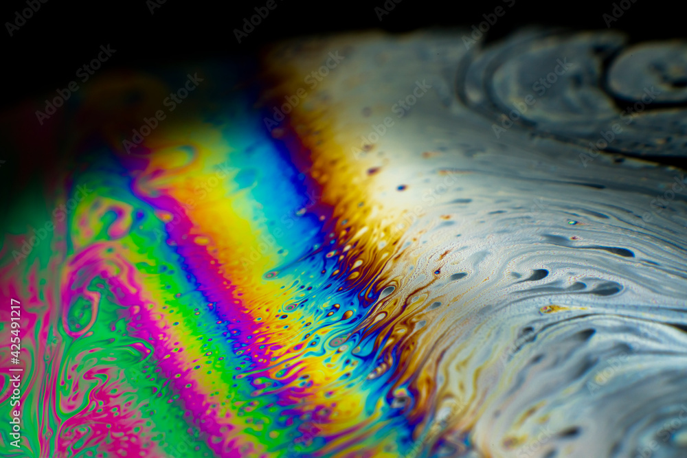 The colorful close-up surface of a soap bubble with weird psychedelic ...