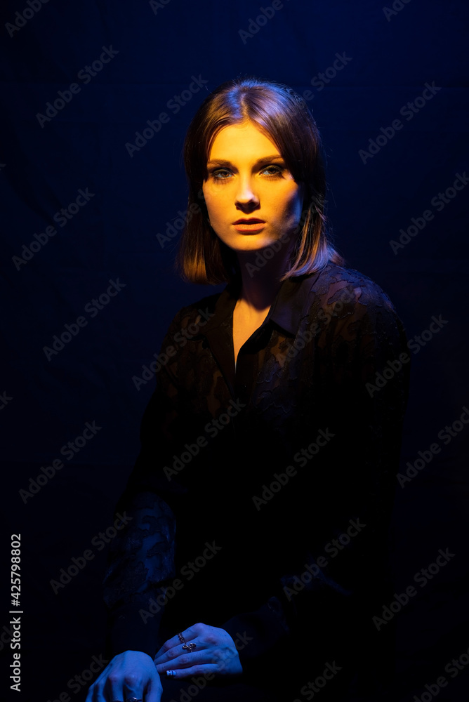 vintage dramatic portrait of a young girl in black. A yellow beam of ...