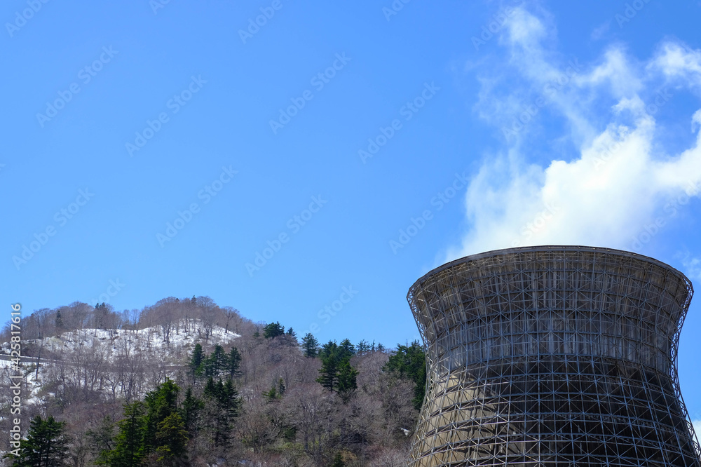 Big construction of chimney with white smoke against snowy forest and ...