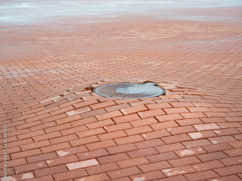 Sagging paving slabs as a result of flooding. Manhole and tiles at ...