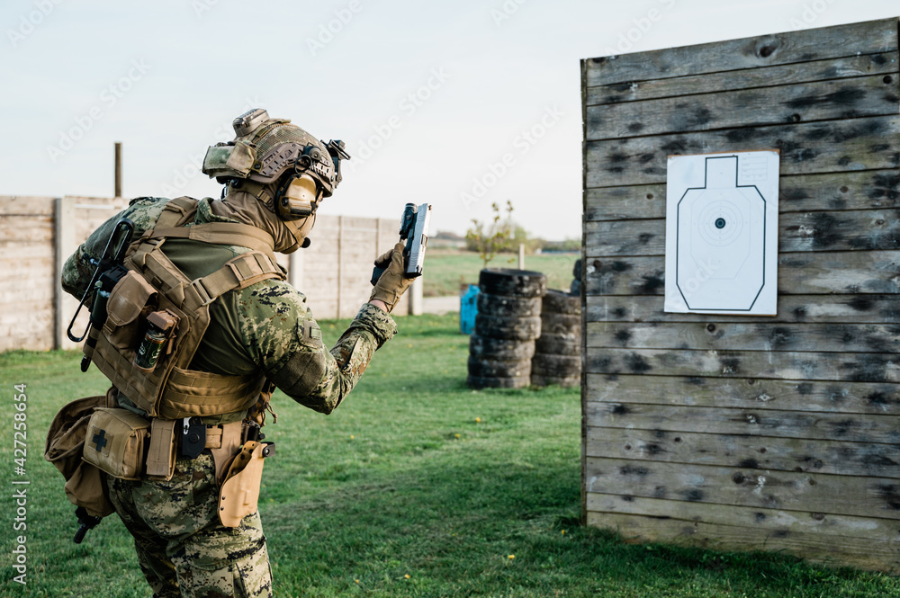 Soldier in the uniform (Cropat woodland pattern) taking aim at the ...