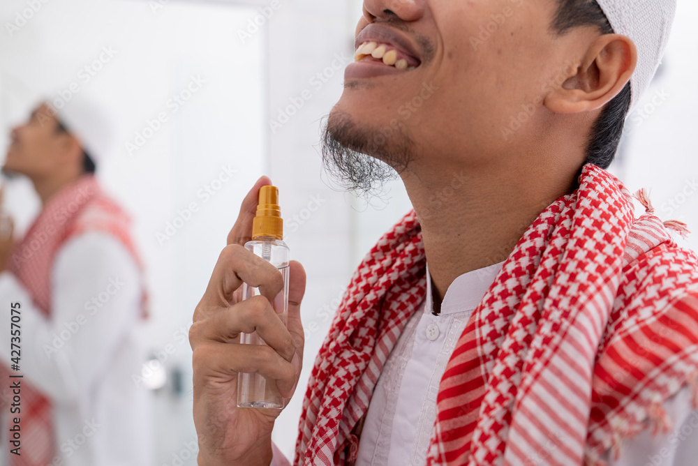 muslim asian man preparing for eid mubarak. get dressed and applying ...