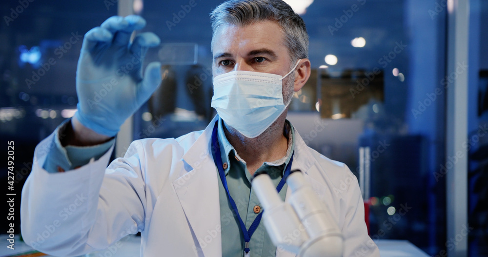 Adult microbiology professional expert diagnosing virus bacteria using ...