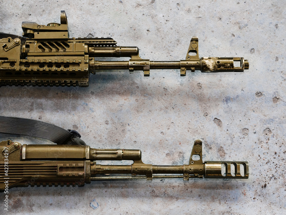 Two custom gold assault rifles close-up lying on the concrete floor top ...