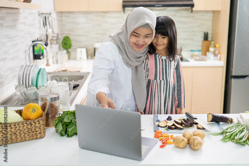 happy muslim asian woman with her daughter cooking together in the ...