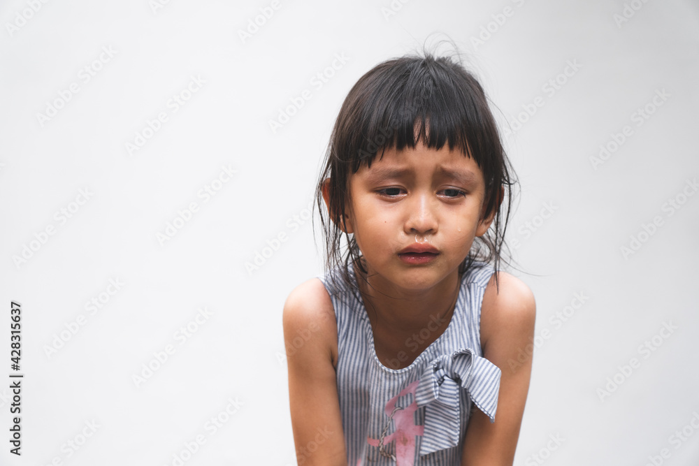 A 5 years old asian little girl is emotional crying in the gray ...