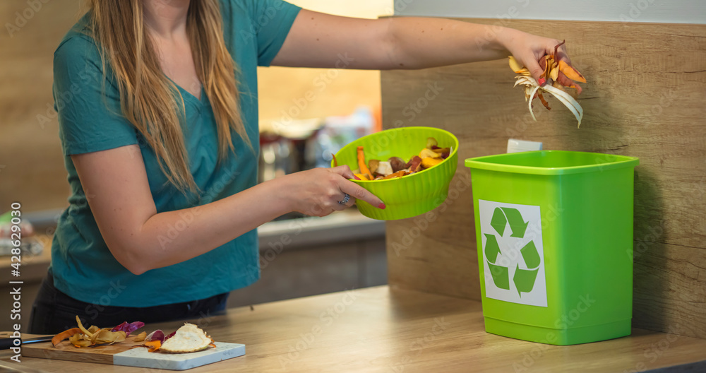Domestic waste for compost from fruits and vegetables. Woman throws ...