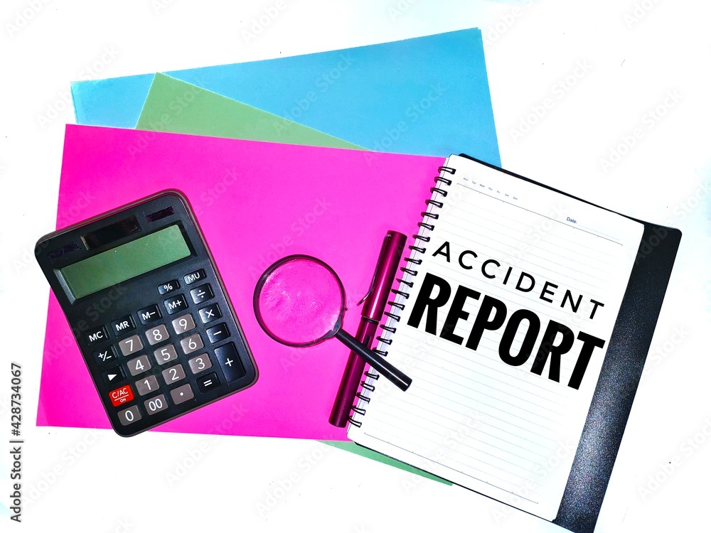 Accident report wording. Written on a note book with a magnifying glass ...
