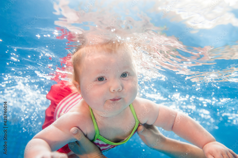 Little baby, girl swimming under water in paddling pool. Diving baby ...