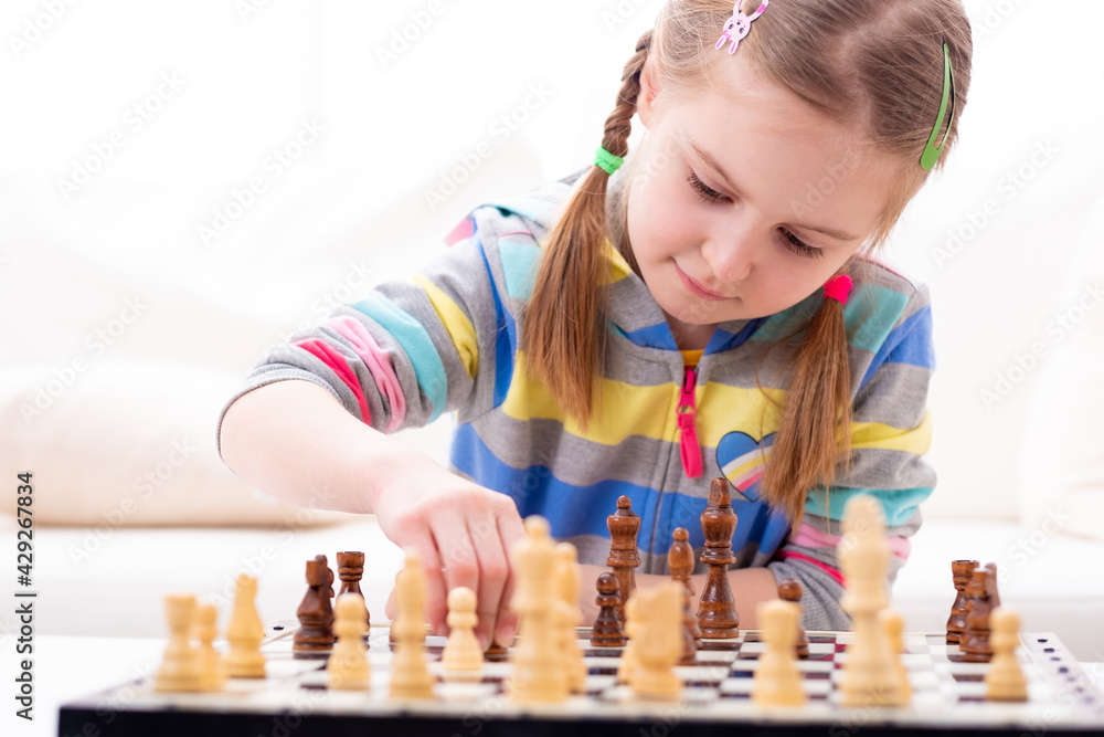 Cute little girl playing chess at home Stock Photo | Adobe Stock