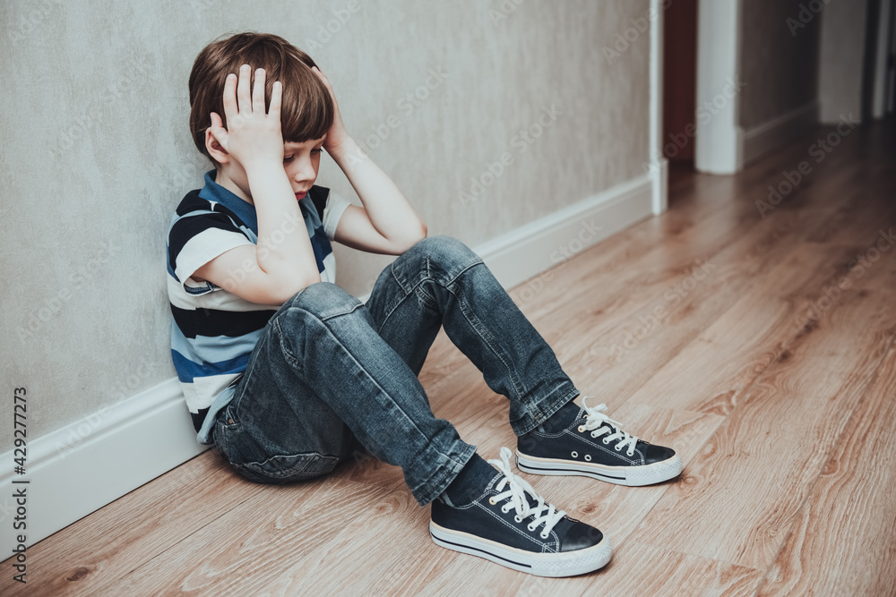 Boy crying covered his face with his hands. Stressed child. Domestic ...