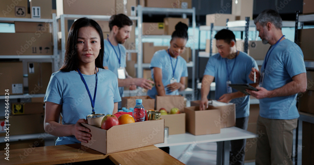 Asian beautiful young female volunteer holding box with person food ...