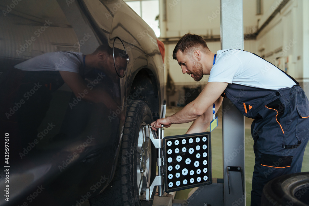 Car mechanic installing sensor adjustment and automobile wheel Stock ...