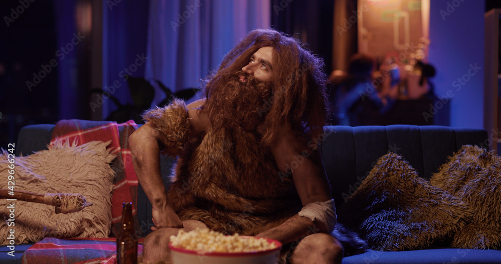 Portrait of funny ancient prehistoric primitive human in animal fur ...