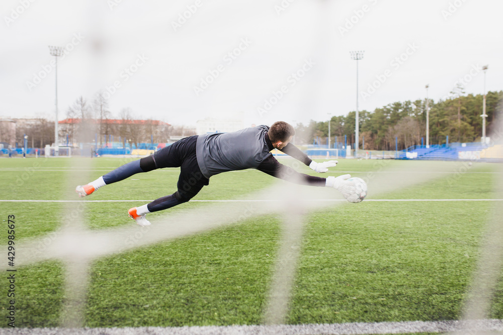 Football goalkeeper throws the ball into the goal - quick reaction of a ...