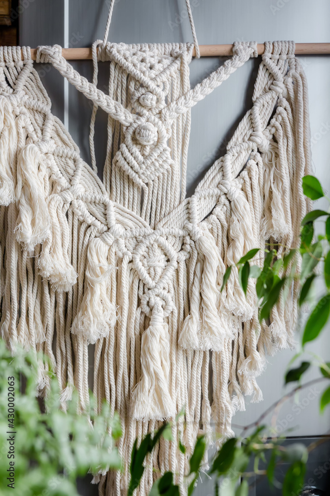 Macrame. Handmade macrame weaving and cotton threads on a rustic wooden ...
