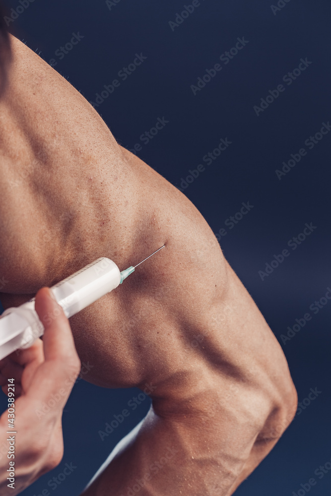 Bodybuilder makes injection of vitamins. Photo of sporty man with ...