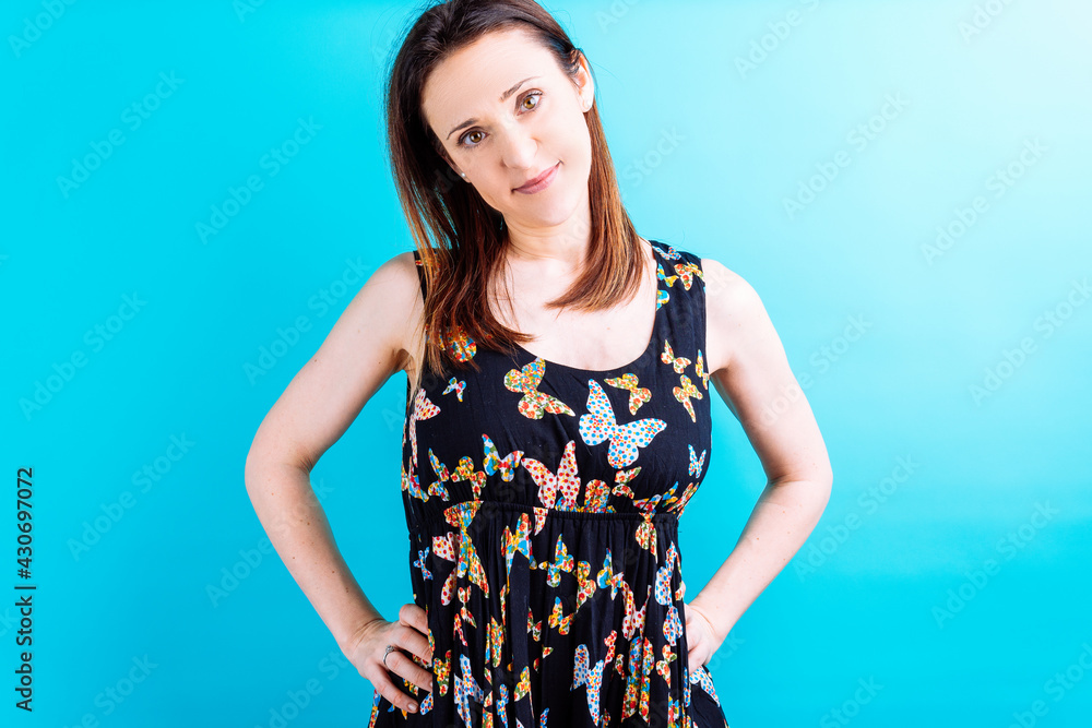 beautiful young woman with hands on hips confident with blue background ...