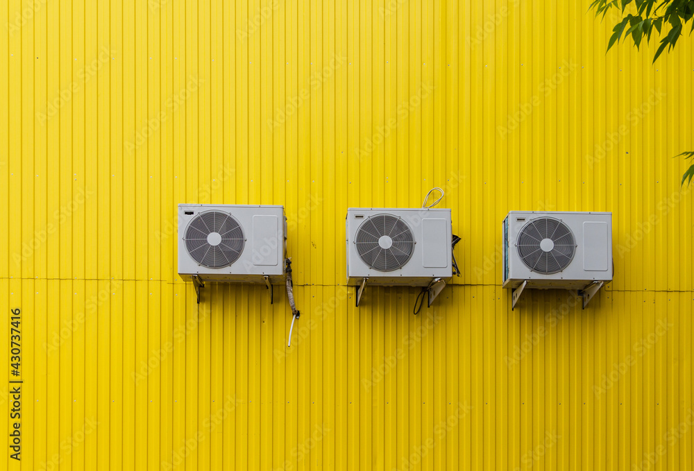 air conditioning on the wall from a yellow profiled sheet, air ...