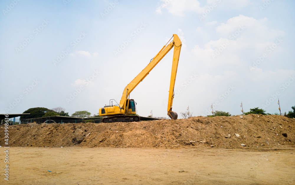 The long boom backhoes land on a pile of soil during digging and ...