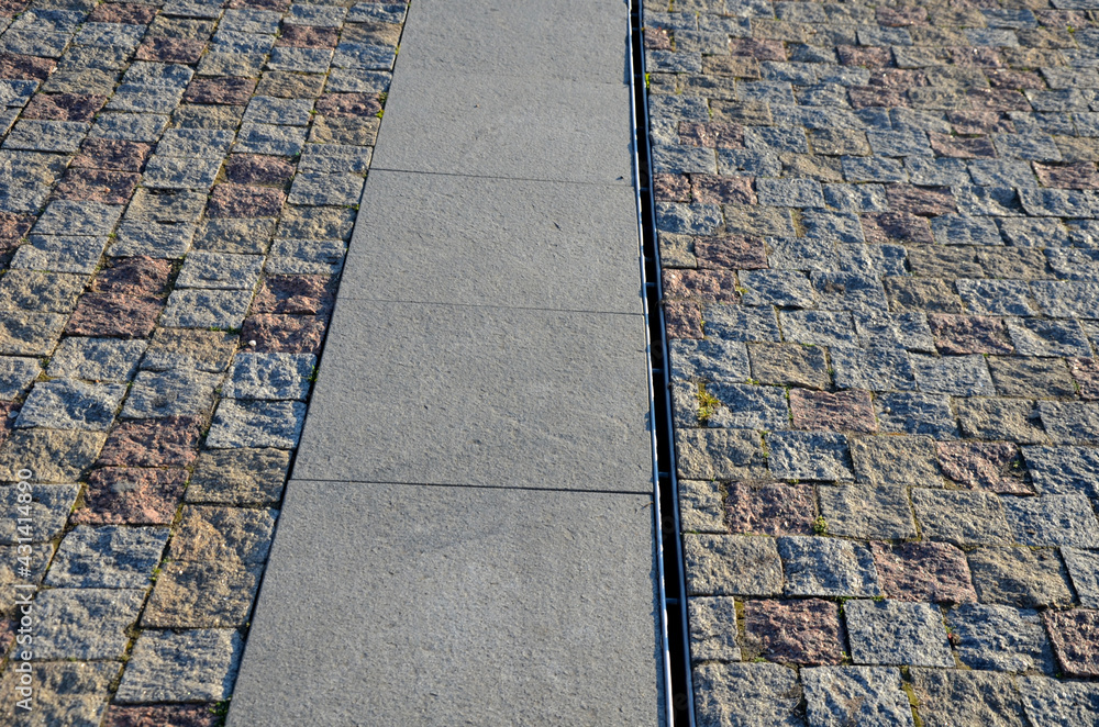 large-format paving made of gray granite. the water is drained in the ...
