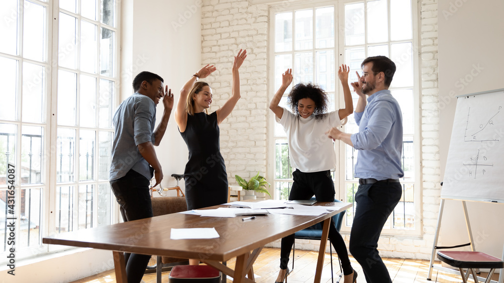 Overjoyed millennial diverse mixed race business people dancing in ...