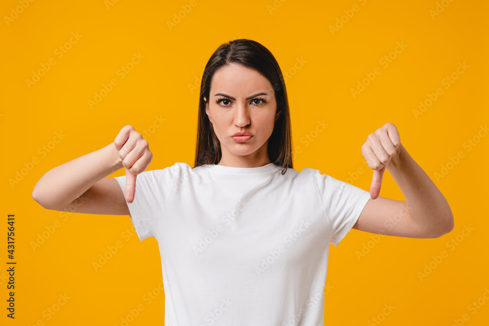 Sad, angry mistrusted young hispanic woman showing thumbs down dislike ...