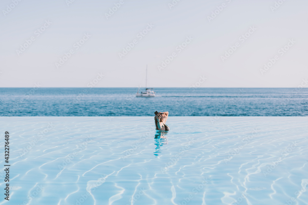 Sexy girl relaxing in infinity pool. Ocean background. Luxury resort ...