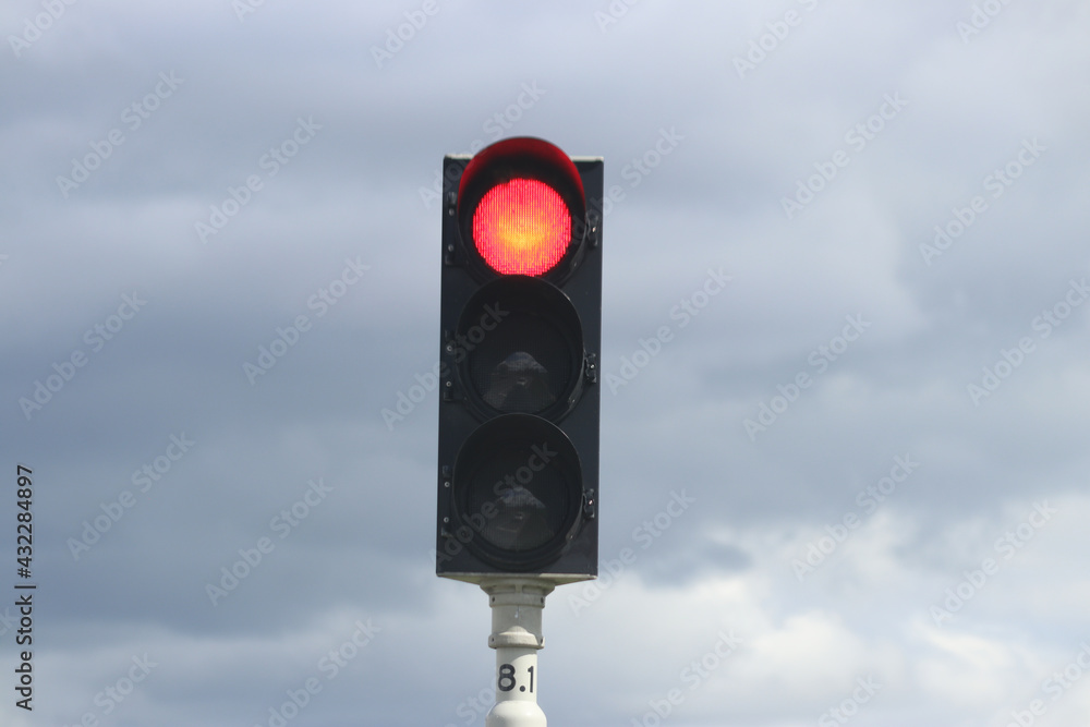 Red light burning in a traffic light at crossing Stock Photo | Adobe Stock