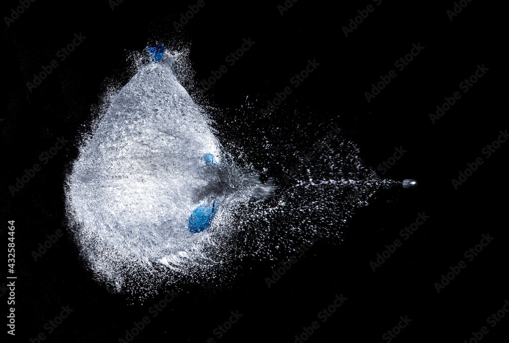 explosion of a water filled balloon on a black background, shot through ...