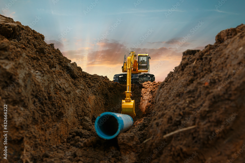 Excavator is digging in the construction site pipeline work on sunset ...