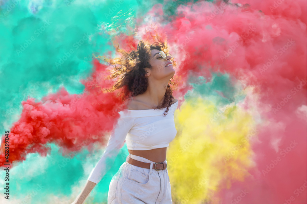 Foto de Stock Beautiful young woman surrounded light up colored smoke ...