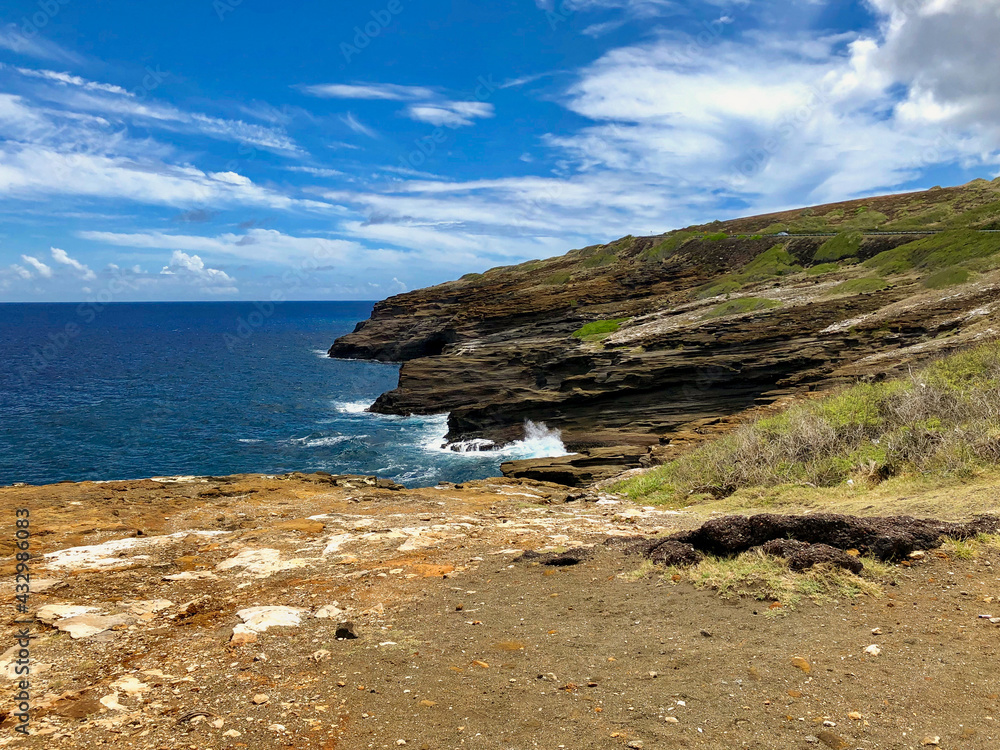 Rocky cliffs and Pacific Ocean wake surf along shoreline of coast of ...