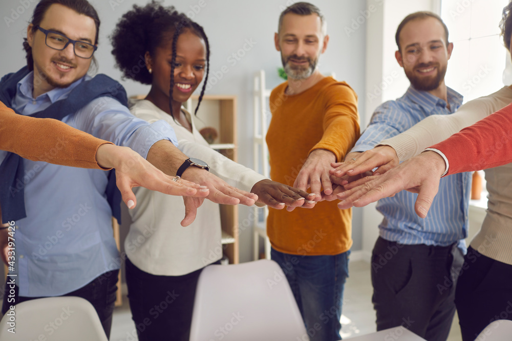 Happy diverse business team members put hands together after corporate ...