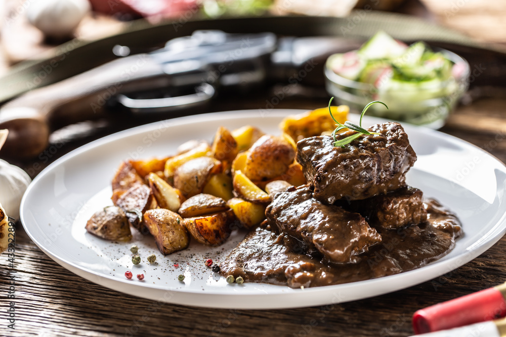 Wild game goulash stew served with roasted potatoes and seasoned with ...