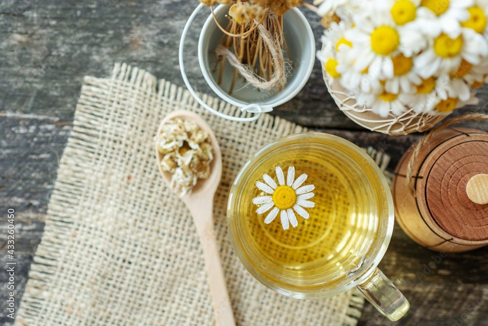 bouquet of daisy flowers chamomile, cup of herbal chamomile tea with ...