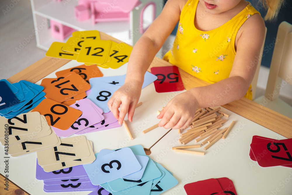 Little caucasian girl studying numbers and math in the classroom ...